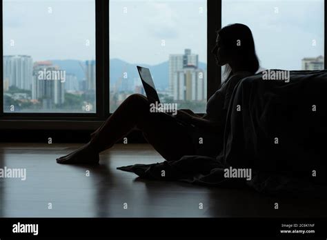 siluet girl working on a laptop and drinking coffee sitting on the