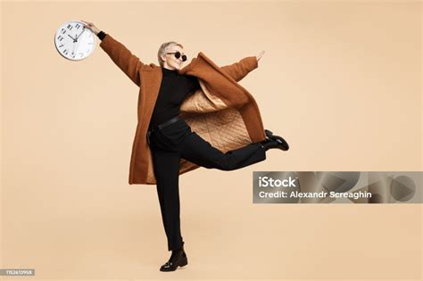 금발 짧은 머리와 코트와 선글라스 춤을 입고 젊은 소식통 여자 웃는 베이 지 배경 위에 고립 된 시계 가을에 대한 스톡 사진 및 기타 이미지 Istock