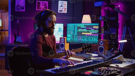 Musical Composer Recording His Guitar Tunes And Adding Piano Key Sounds Creating A Beautiful