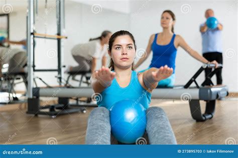 People Of Different Ages Pressing Core And Clutching Mini Pilates Balls