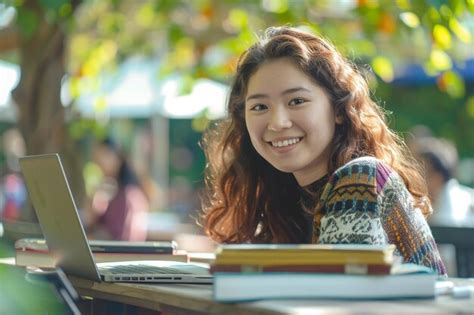 Premium Photo A Girl With A Laptop And A Book On Her Lap