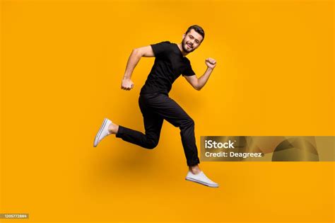 잘 생긴 밀레니엄 남자의 전신 프로필 사진 점프 높은 돌진 쇼핑몰 최고의 블랙 프라이데이 제공 시즌 착용 검은 색 티셔츠 바지