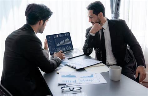 Busy Analyst Team Discussing Financial Data On Laptop Fervent Stock