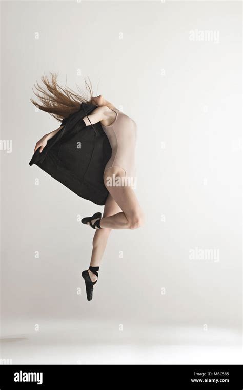 Young Beautiful Dancer In Beige Swimsuit Dancing On Gray Background