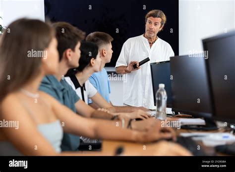 Positive Teacher Leading Group Of Youth Attending Computer Class Stock