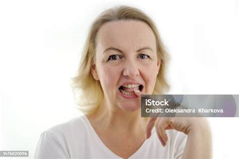 제안을 생각하다 여자 이빨로 검지 손가락을 물고 눈을 뜨고 흰색 배경에 프레임을 들여다 보면 거부하기 어려운 흥미로운 제안 재미