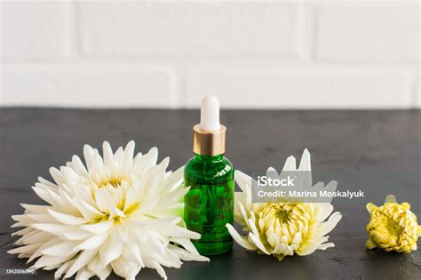 흰색 벽돌 벽과 꽃의 배경에 녹색 유리로 만든 파이펫장식병으로 세럼을 보습 개념에 대한 스톡 사진 및 기타 이미지 개념