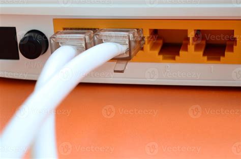 The Internet Cable Plugs Are Connected To The Internet Router Which Lies On A Bright Orange