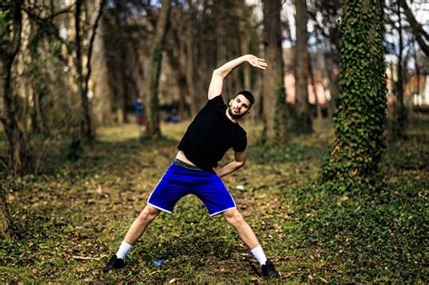 공원이나 체육관 운동에서 실행하기 전에 워밍업을위한 운동을 스트레칭 스포티 한 남자 피트니스와 건강한 라이프 스타일 컨셉 25