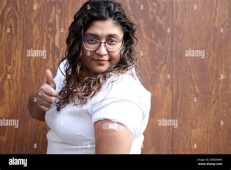 Latin Adult Woman With White Blouse Wavy Hair And Glasses Shows Her Arm