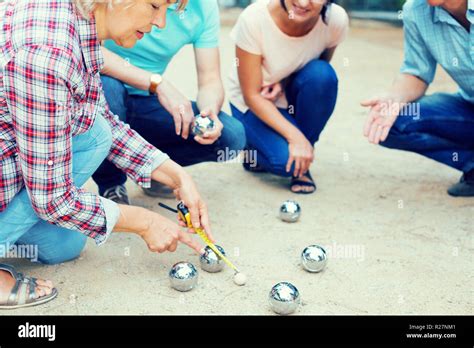 Portrait Of Friendly Mature Couples Playing Petanque At Leisure Stock