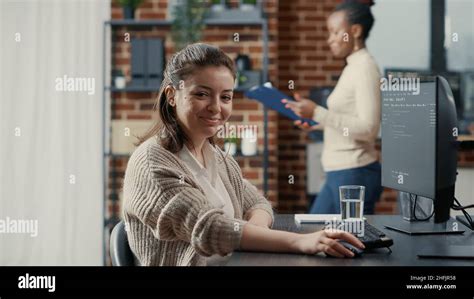 Programer Typing Source Code On Computer Keyboard Turning Head And Smiling At Camera Casual