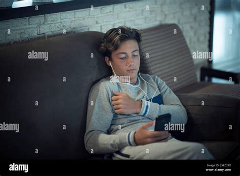 Teenager Liyed Auf Dem Sofa Des Hauses Allein Mit Sein Telefon Und Musik H Ren Videos Ansehen