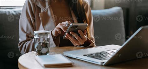 mujeres contando monedas en la calculadora sacando de la alcancía mano que sostiene la pluma