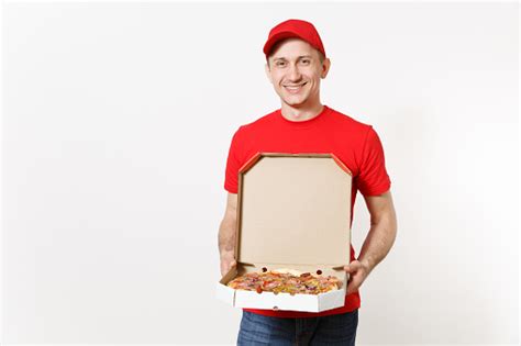 배달 빨간 유니폼을 입고 흰색 배경에 고립 된 사람을 웃 고 모자 티셔츠 택배 또는 골 판지 Flatbox에서 이탈리아 피자를 들고 딜러로 일하고 있는 남자 Pizzaman