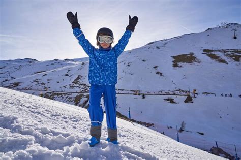 Premium Photo Boy With Raised Arms In Snowy Mountains