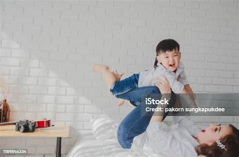 아시아 일본 가족 아버지 어머니 아들 흰색 셔츠를 입고 아이 들고 사진 에 침실에 흰색 방 어린 시절 라이프 스타일에 아들의 귀여움을 즐겁게 하는 추억의 순간을 유지 합니다