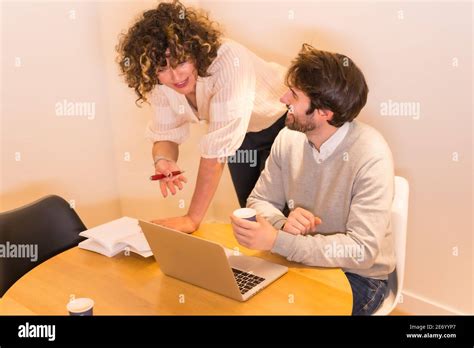 Male And A Female Discussing A Project Around A Round Table At The Office Stock Photo Alamy