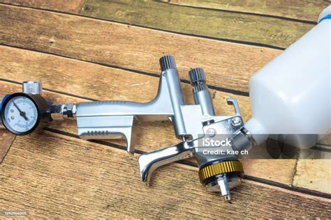 나무 바닥에 페인트 스프레이 산업 회화 및 코팅에 사용되는 산업 크기 스프레이 건을 들고 화가의 팔 손의 이미지 배경 클리핑 파트에 절연 0명에 대한 스톡 사진 및 기타