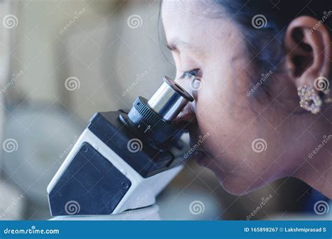 Close Up Of Woman Using A Microscope In A Laboratory Female Scientist Busy In Looking Into
