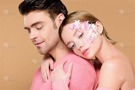妇女与鲜花在脸上拥抱男子孤立的米色