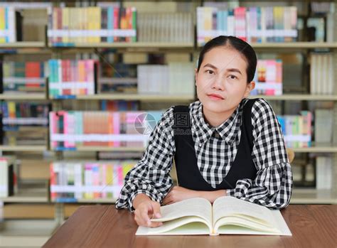 年轻的亚洲女人在图书馆看书高清图片下载 正版图片504248436 摄图网