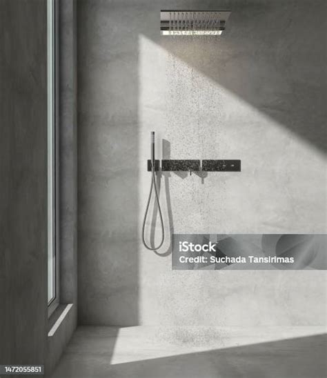 크롬 샤워기가 있는 현대적이고 미니멀한 로프트 욕실 디자인 회색 광택 시멘트 벽의 창문에서 햇빛이 비치는 레인 샤워기 헤드