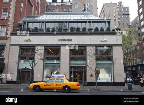 A Yellow New York Taixi Cab Passing The Hermes Fashion Store Madison