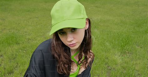 초록색 모자와 검은색 재킷을 입은 여성이 풀밭에 앉아 있다 사진 Unsplash의 소녀 이미지