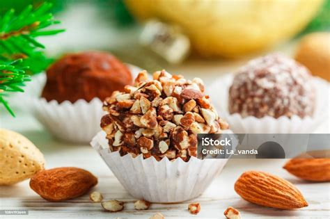 수 제 초콜릿 트 뤼 플과 아몬드 코코넛 비스킷 빵 전나무 지점과 축제 장난감 테이블에 흰 접시에 공 크리스마스와 새 해 선물입니다 미식가입니다 선택적 초점 0명에 대한