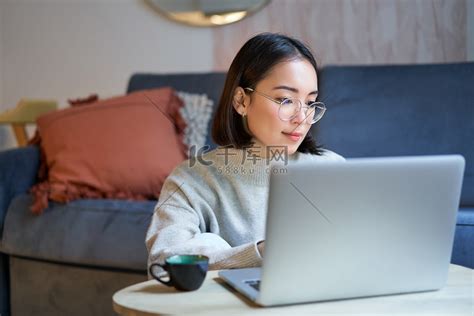 自雇的年轻韩国女性在远程工作在笔记本电脑上打字在家客厅学习高清摄影大图 千库网