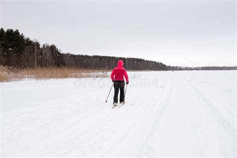 Female Person Exercising Cross Country Skiing On The Frozen Lake Ice