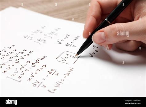 Student Writing Different Mathematical Formulas On Paper Closeup Stock