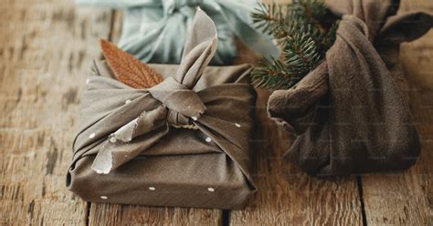 제로 낭비 세련 된 크리스마스 선물 크리스마스는 소박한 나무 테이블에 전나무 가지와 잎으로 천으로 싸여 있습니다 친환경 겨울 휴가 후로시키 선물 즐거운 휴일 보내세요