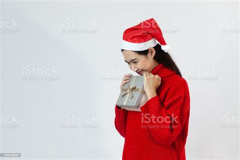 젊은 발크 머리 아시아 여자 입고 산타 모자와 빨간 셔츠 들고 에이은과 금 선물 선물 선물 상자 에 흰색 배경 12월에 대한