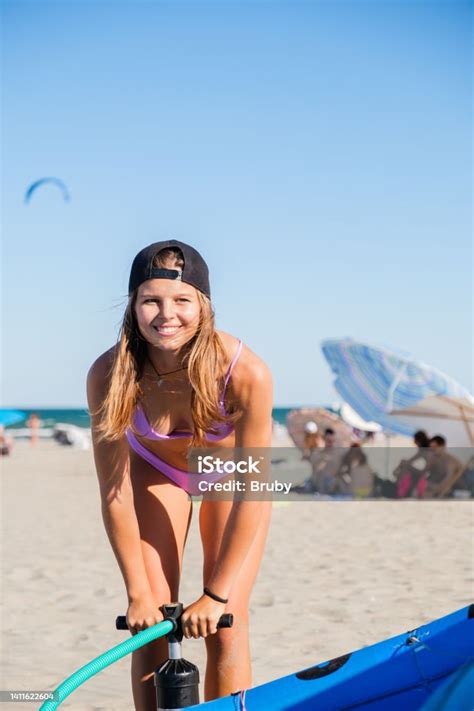 아름다운 Kitesurfer 소녀 해변에서 연을 부풀려 바다에서 사용할 준비가되었습니다 스포티 한 여성과 여름 스포츠 활동의