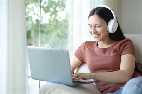 Happy Asian Woman Wearing Headphone Using Laptop At Home Stock Image