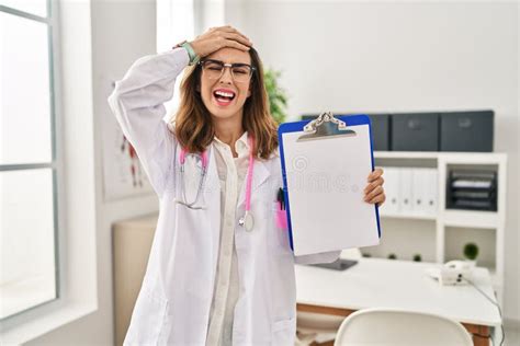 Young Doctor Woman Holding Clipboard Stressed And Frustrated With Hand
