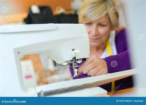 Female Tailor Threading Bobbin Into Sewing Machine Case Stock Image