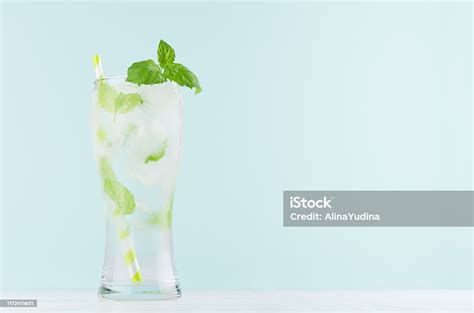 녹색 잎 얼음 조각 줄무늬 빨대 흰색 나무 테이블에 우아한 유리미네랄 워터 민트 색상 벽과 서리가 내린 민트 레모네이드 녹색에