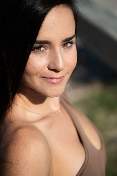 Beautiful Dark Haired Girl Looking At The Camera With A Smile On Her