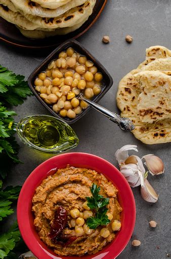 병아리콩 햇볕에 말린 토마토 녹색 고수 잎을 얹은 후무스와 피타 빵을 따로 따로 돌 테이블에 얹은 후무스 건강한 식생활에 대한