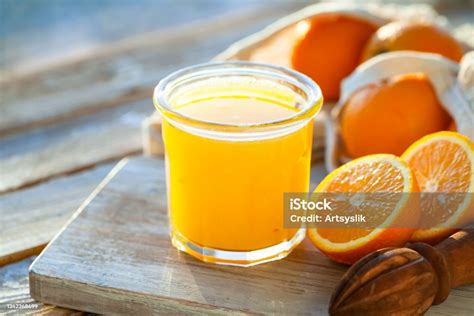 나무 테이블에 갓 짜진 오렌지 주스 한 잔 비타민의 천연 공급원 이상적인 아침 식사를 위한 건강한 음료 화창한 여름 날 닫고 텍스트를 위한 공간을 복사합니다 오렌지 감귤류