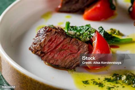 Steak Daging Sapi Yang Diiris Dengan Bayam Di Atas Piring Di Atas Meja