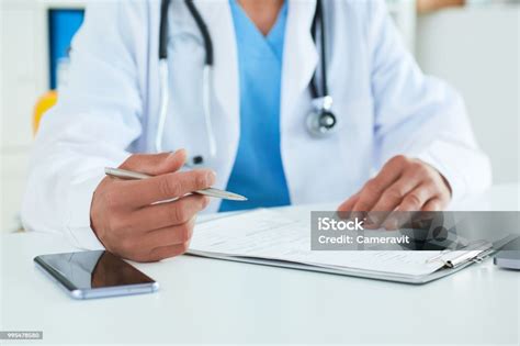 복용 하는 남성 의사의 손에 메모 또는 고객의 의료 카드에 채웁니다 또는 약물을 처방 구 라운드 환자 방문 확인 의료 계산 및