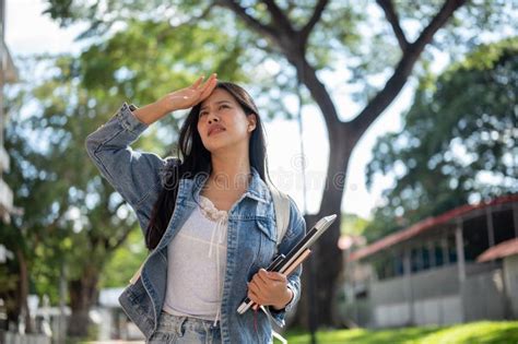 A Tired Sweaty Asian Female College Student Feels Hot And Uncomfortable While Walking Outdoors