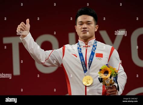 Shi Zhiyong Of China Celebrates On The Podium After Winning The Gold Medal In The Mens 73kg