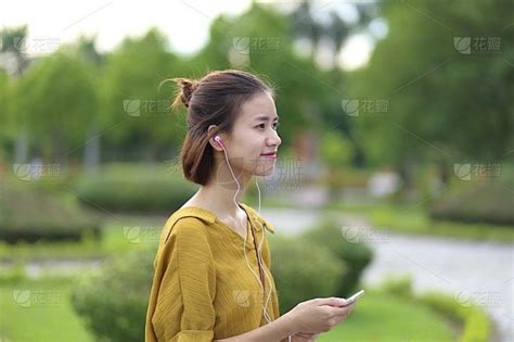 年轻女子在用智能手机听音乐