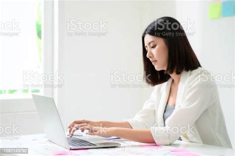 집에서 일의 개념 책상에 서류 문서와 사무실 방에서 컴퓨터 노트북에서 일하는 젊은 아시아 비즈니스 여성 여자에 대한 스톡 사진