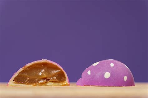 수제 보라색 초콜릿 봉봉 슬라이스를 닫습니다 손으로 그린 사탕의 구색 사탕은 반으로 자른다 복사 공간이 있는 모형 보라색 배경에